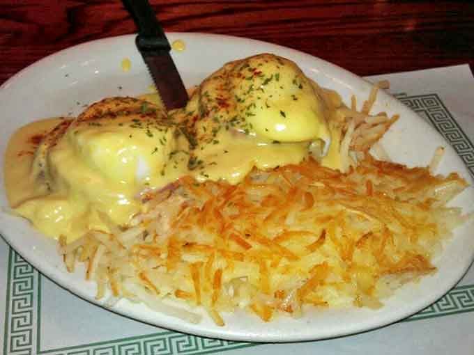 Eggs Benedict that would make a French chef weep with joy, perched atop a golden throne of hash browns crispy enough to be heard three tables away.