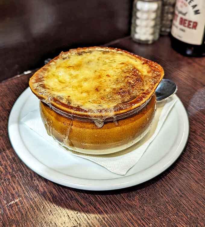 The French onion soup arrives like a bubbling cauldron of comfort, with a cheese pull that deserves its own Olympic medal.