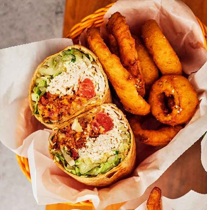 A breakfast burrito and onion rings that proves whoever said "breakfast foods can't play well with lunch items" has never experienced true culinary harmony.