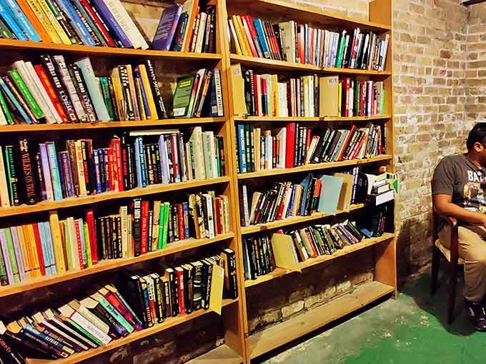 Exposed brick walls frame wooden shelves that bow slightly under the weight of countless stories &ndash; a beautiful burden of knowledge.
