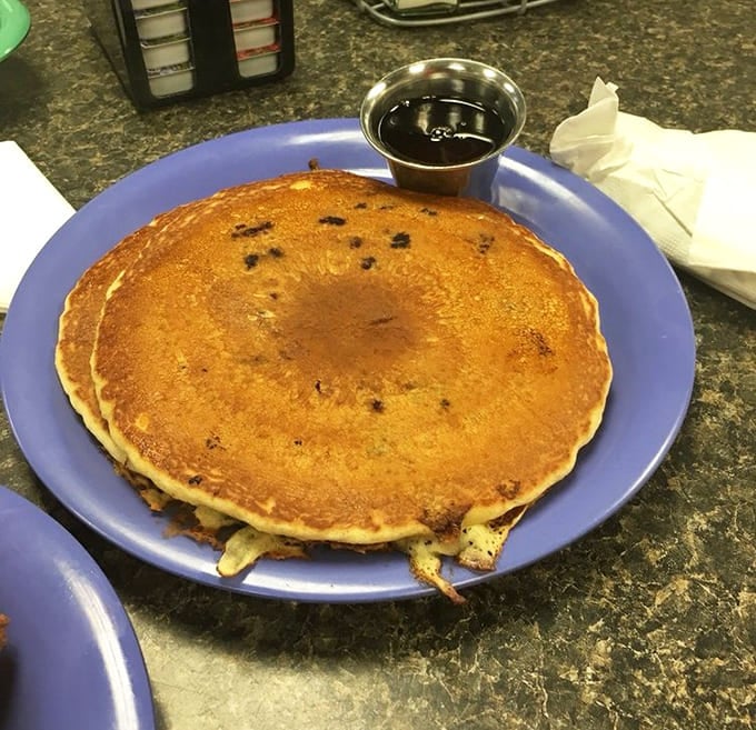 Pancakes so perfectly golden they could win medals, served with a side of maple syrup in that iconic metal container diners have used since time immemorial.