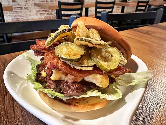 This isn't just a burger—it's an architectural marvel. Crispy pickles and bacon stacked so high you'll need to strategize your first bite.