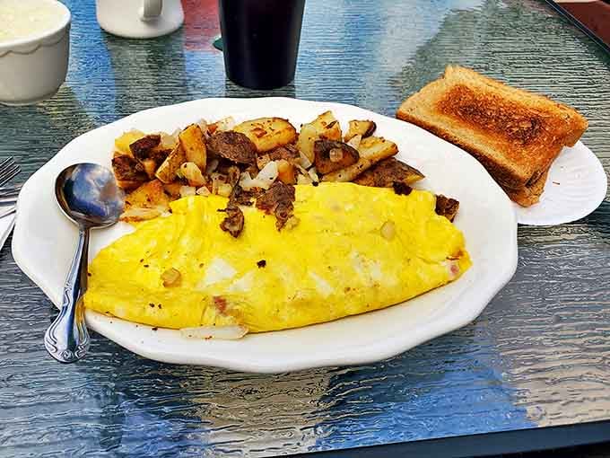A perfectly executed omelet with home fries and toast &ndash; breakfast fundamentals done right. No molecular gastronomy needed when the basics taste this good.
