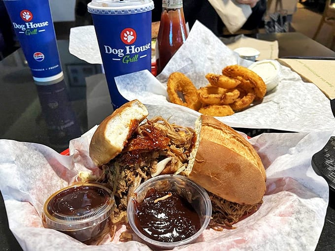 The pulled pork sandwich arrives with twin sidekicks of barbecue sauce, proving that sometimes the best things in life come with backup dancers.