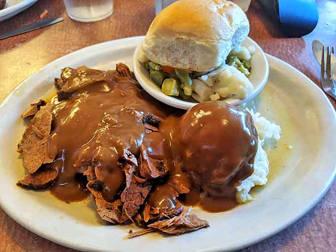 Roast beef that surrenders at the mere sight of a fork, swimming in gravy that should be bottled and sold as liquid comfort.
