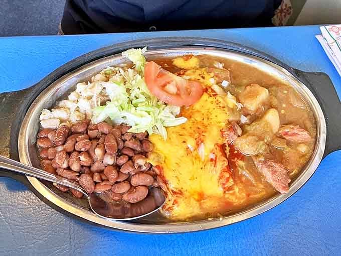 A sizzling oval of New Mexican bliss&mdash;beans, melted cheese, and green chile stew that could make a grown person weep with joy.