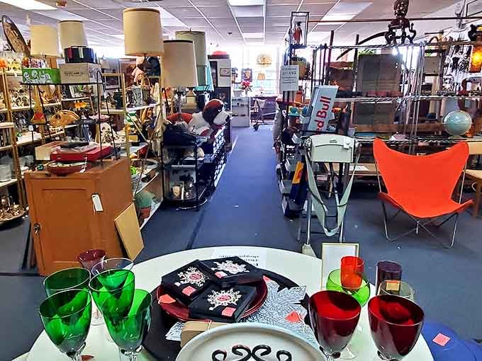 Mid-century modern meets vintage kitsch in this aisle where emerald glassware pops against ruby companions. The butterfly chair is just a bonus.