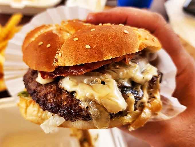 Not just a burger, but a declaration of flavor independence. The melted cheese cascades over the patty like lava from a delicious meat volcano.