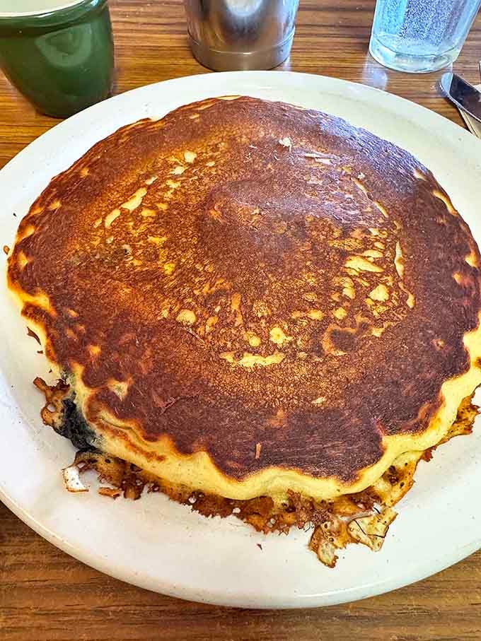 This isn't just a pancake; it's a golden-brown canvas of happiness that hangs over the edge of the plate. Perfection doesn't need to be complicated.