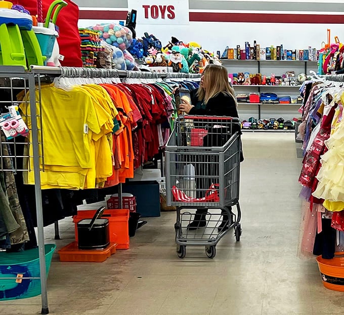 The thrill of the hunt in action&mdash;a shopper navigates colorful children's clothing while her cart gradually fills with potential treasures.