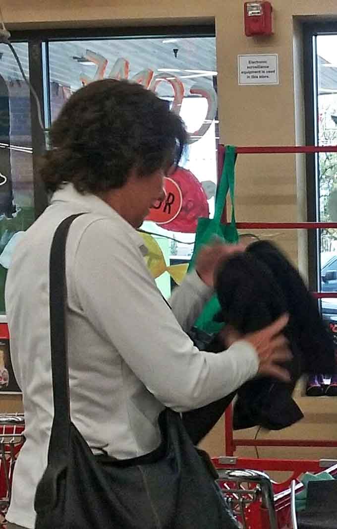 A shopper examines potential treasures with the focus of an archaeologist. Every visit to Savers requires this level of careful inspection.