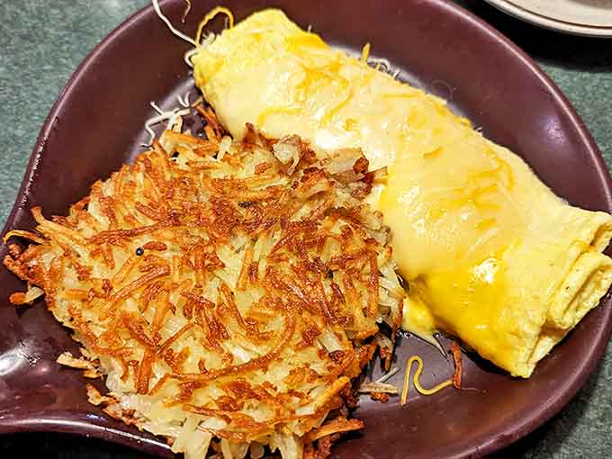 The perfect marriage: a golden omelet alongside hash browns with that magical crisp-outside-tender-inside texture that haunts your breakfast dreams.