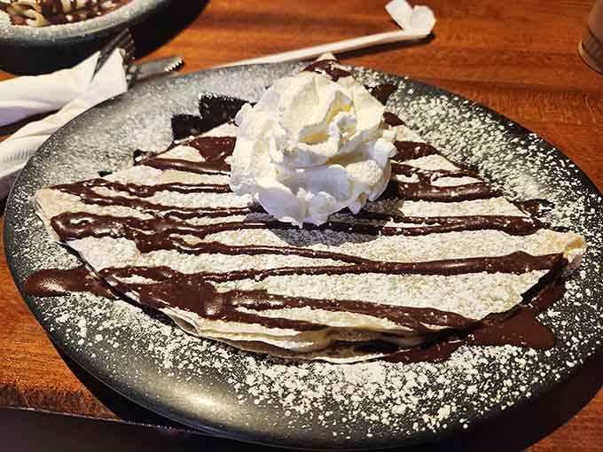 Chocolate drizzles transform this simple crepe into edible artwork &ndash; proof that sometimes the most beautiful masterpieces are meant to be devoured.