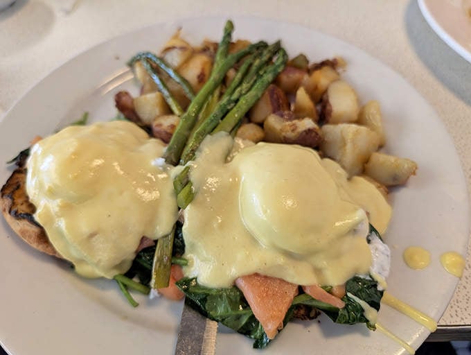 Eggs Benedict gets the royal treatment with perfectly poached eggs, vibrant asparagus, and hollandaise sauce that would make Julia Child smile.
