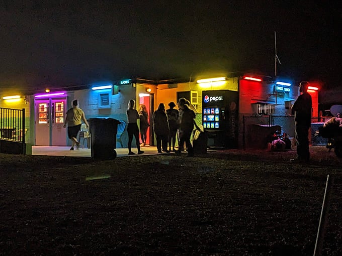 The concession stand comes alive after dark, its rainbow of neon lights beckoning moviegoers with the siren song of buttery popcorn and ice-cold sodas between features.