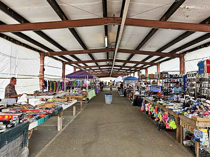 Long covered aisles display tools, clothing, and collectibles as shoppers move steadily through vendor tables.