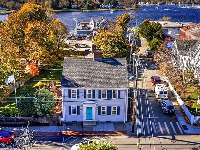 A classic New England colonial home with bright blue door sits near the water in Warren, where historic homes and harbor views create peaceful living.