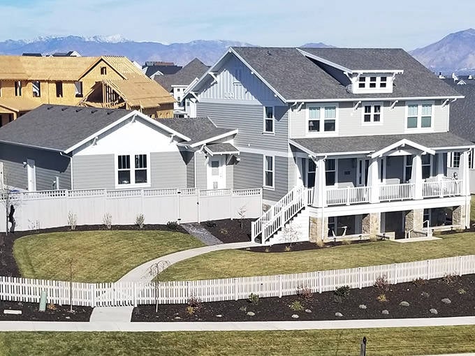 New homes with white picket fences dot the landscape where mountain living meets suburban comfort perfectly.