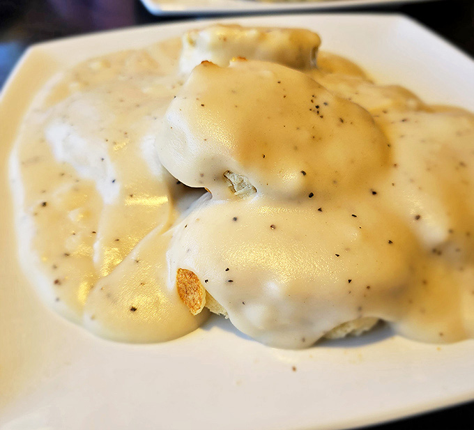 Country gravy blankets these biscuits like a warm February snow, creating comfort food that could make even the toughest cowboy misty-eyed.
