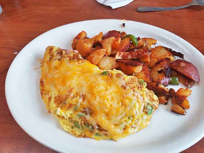 An omelet that's seen the inside of a cheese factory and lived to tell the tale, paired with potatoes that redefine the word "crispy."