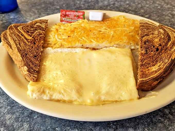 Breakfast geometry at its finest &ndash; a perfect triangle of melted cheese omelet flanked by marble rye sentinels standing guard.