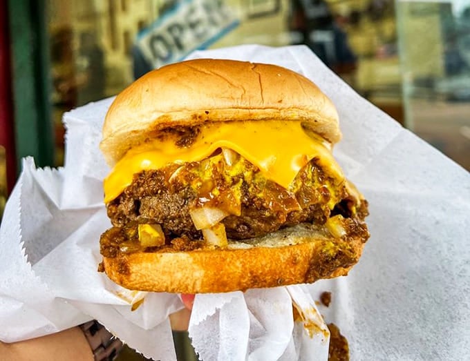 Melted cheese cascading over seasoned beef, creating that perfect burger alchemy that no fancy restaurant can replicate.