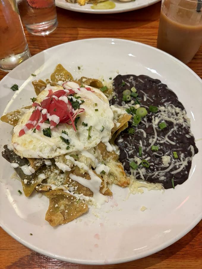 Chilaquiles that blur the line between breakfast and lunch, where crispy tortillas, eggs, and black beans perform a delicious balancing act.