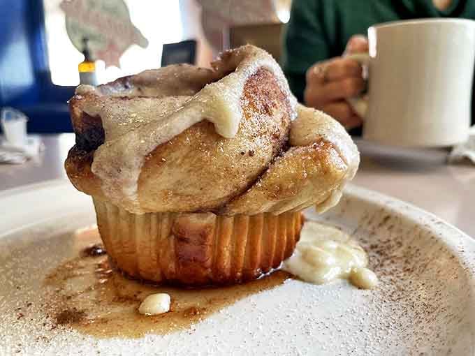 Not just any cinnamon roll – this is the heavyweight champion of breakfast pastries, glazed to glistening perfection.