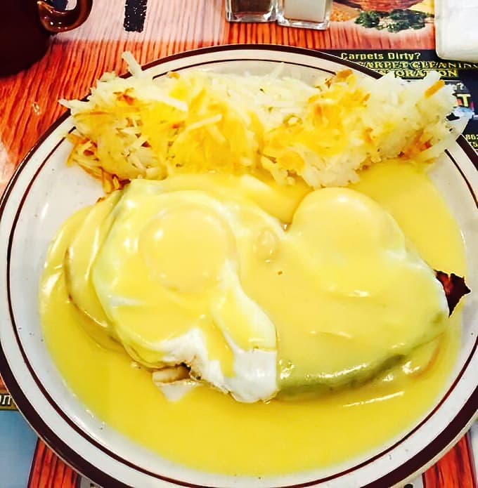 Eggs Benedict that would make any brunch enthusiast weak at the knees, with hollandaise sauce cascading like a golden waterfall over perfectly poached eggs.