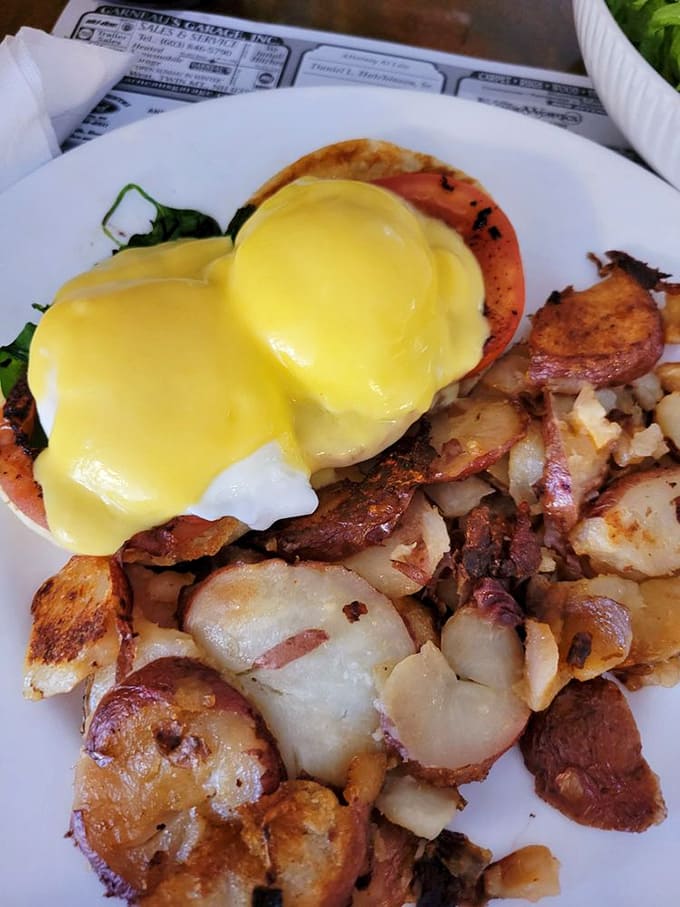 Hollandaise sauce cascades like a golden waterfall over this eggs benedict, transforming an ordinary morning into something worth getting out of bed for.