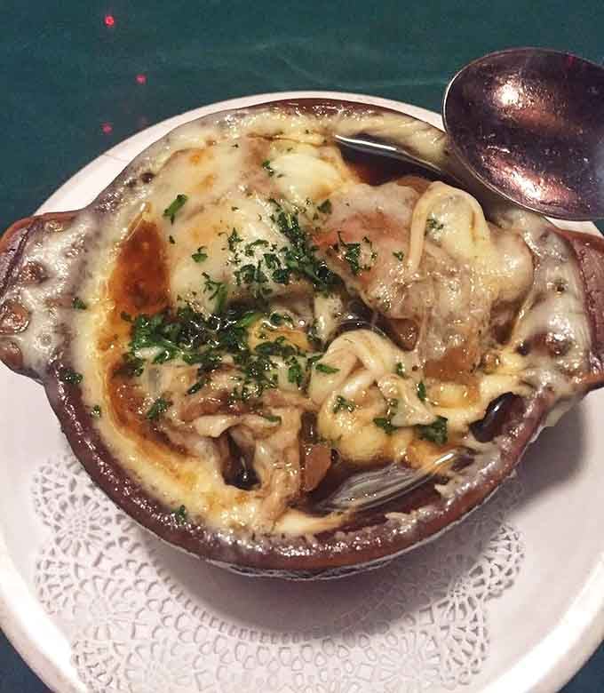 French onion soup that's worth the cheese pull photo op &ndash; a bubbling cauldron of savory broth topped with a golden crown.