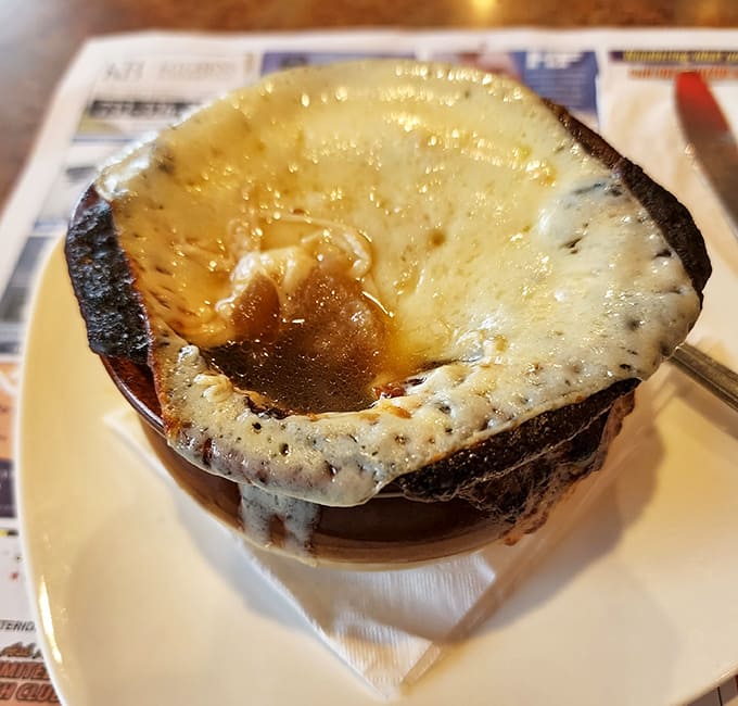 French onion soup: where cheese meets broth in a bubbling romance that's lasted longer than most Hollywood marriages. That golden crust is pure edible sunshine.