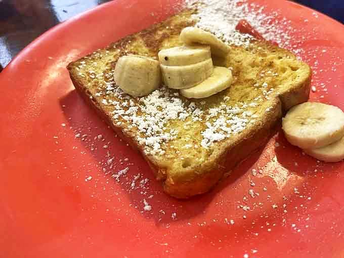 French toast that's achieved that mythical balance: crisp edges, custardy center, and just enough powdered sugar to make you feel like you're getting away with something.