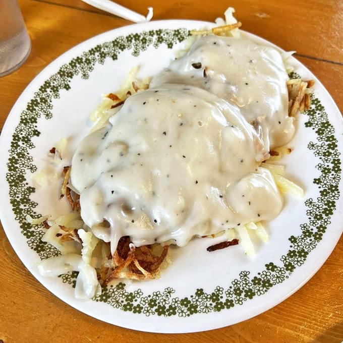 Comfort food poetry: golden hash browns beneath a cascade of homemade sausage gravy—the kind of dish that makes diets weep in defeat.