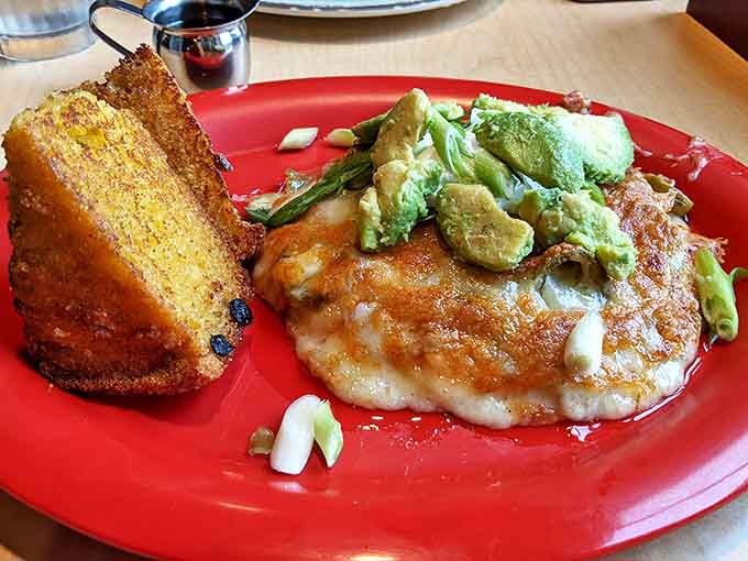Breakfast alchemy at its finest: a golden cornbread companion alongside an omelet crowned with fresh avocado &ndash; proof that mornings in Vermont are worth waking up for.