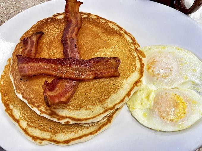 Golden pancakes with bacon arranged like a delicious plus sign &ndash; simple math that always equals satisfaction.