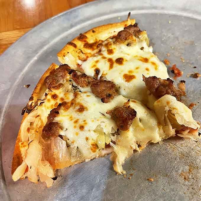 A slice that breaks all the rules yet somehow works brilliantly—sauerkraut and pizza finding harmony like an unlikely buddy-cop movie.