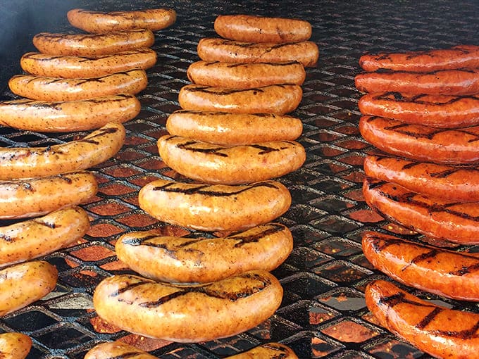 Sausages lined up like edible soldiers, their grilled skins bearing the battle scars of perfect temperature control.