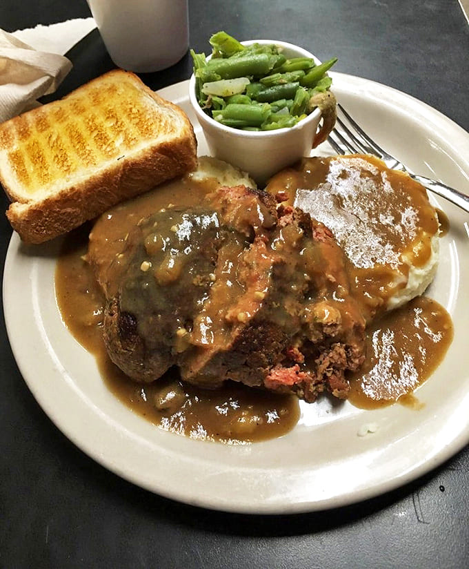 Meatloaf gets the Louisiana treatment here, smothered in rich gravy that demands to be sopped up with that perfectly grilled Texas toast.
