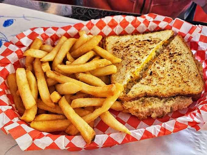 A tuna melt and fries served in a red checkered basket &ndash; comfort food that whispers, "Don't worry, your diet starts tomorrow."