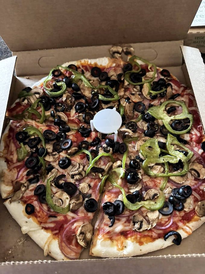 A vegetarian's delight that even carnivores covet—mushrooms, green peppers, black olives, and onions arranged like edible art on a pizza canvas.