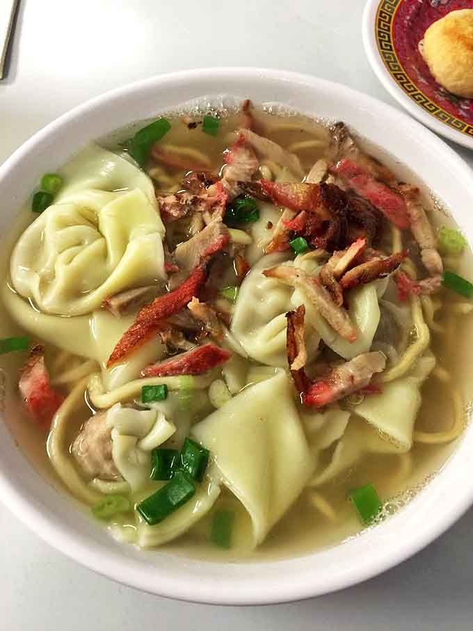 Delicate wontons floating in clear broth alongside tender noodles. Like edible origami that somehow tastes even better than it looks.