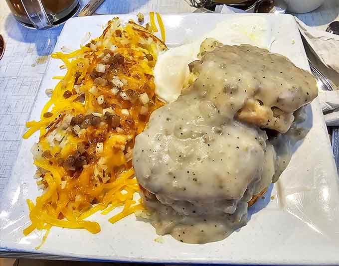 Biscuits and gravy that would make your Southern grandmother both jealous and proud—a creamy cascade of comfort atop golden islands of buttery dough.