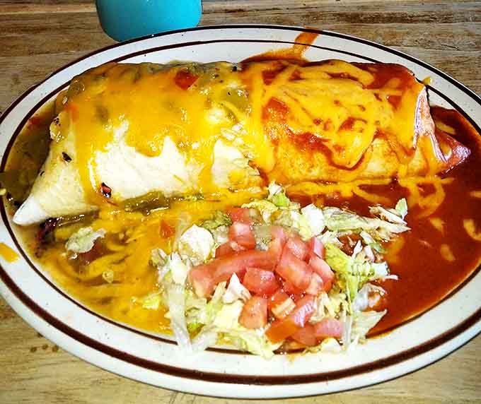 Christmas comes daily here – red and green chile smothering a burrito that's been tucked in with a blanket of melted cheese and fresh lettuce.