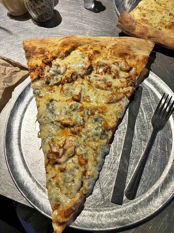 This buffalo chicken slice isn't just food &ndash; it's an engineering marvel of crispy crust supporting a generous landscape of toppings.