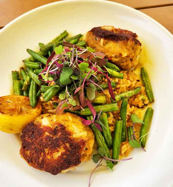 These golden crab cakes aren't just dinner, they're edible art&mdash;perfectly seared and nestled among vibrant green beans and aromatic rice.