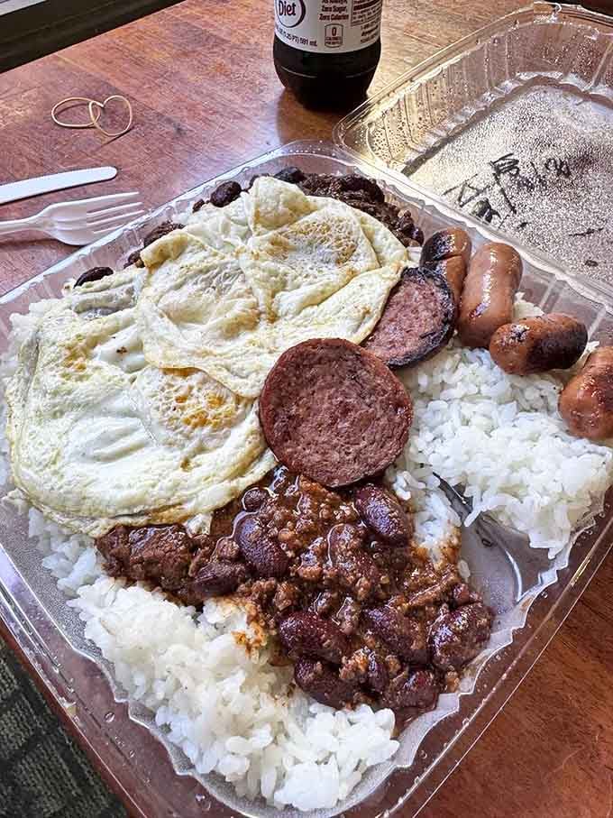 Behold the breakfast of champions: eggs, Portuguese sausage, and chili over rice—a combination that would make even Elvis say "that's too indulgent."