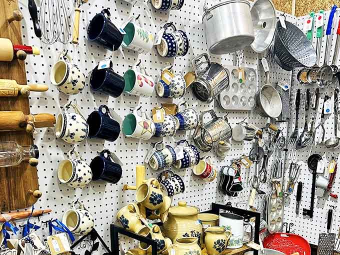 A pegboard symphony of kitchen nostalgia, where Polish pottery meets vintage measuring cups in a display that would make any home cook swoon.