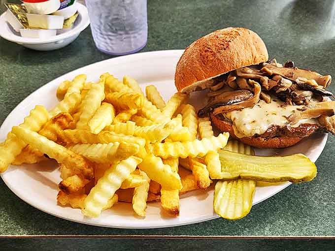 This isn't just a mushroom Swiss burger—it's a towering achievement of beef, melted cheese, and sautéed mushrooms that demands respect and extra napkins.