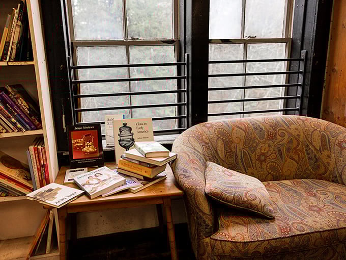 Exposed beams frame these weathered wooden shelves where sunlight streams through windows, illuminating both pages and the reader's imagination.